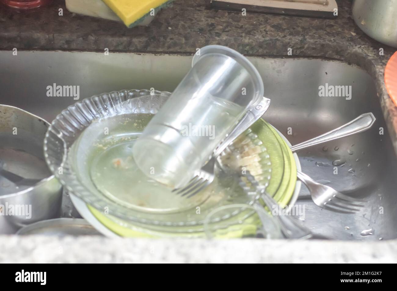 Dirty dishes, dishes, cutlery and dirty pots in a simple home sink,real ...