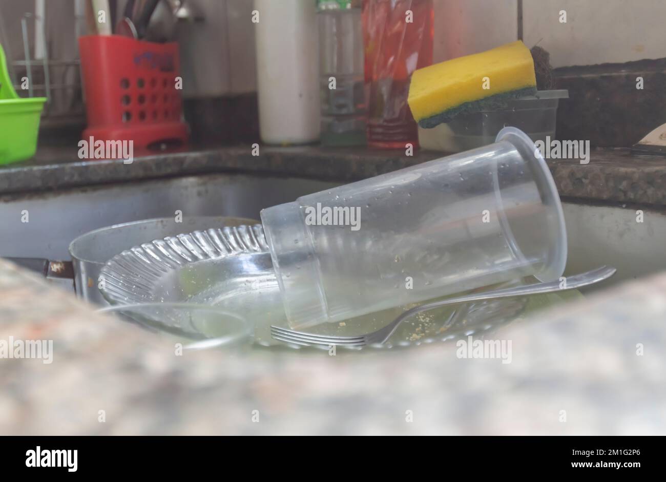Dirty dishes, dishes, cutlery and dirty pots in a simple home sink,real ...