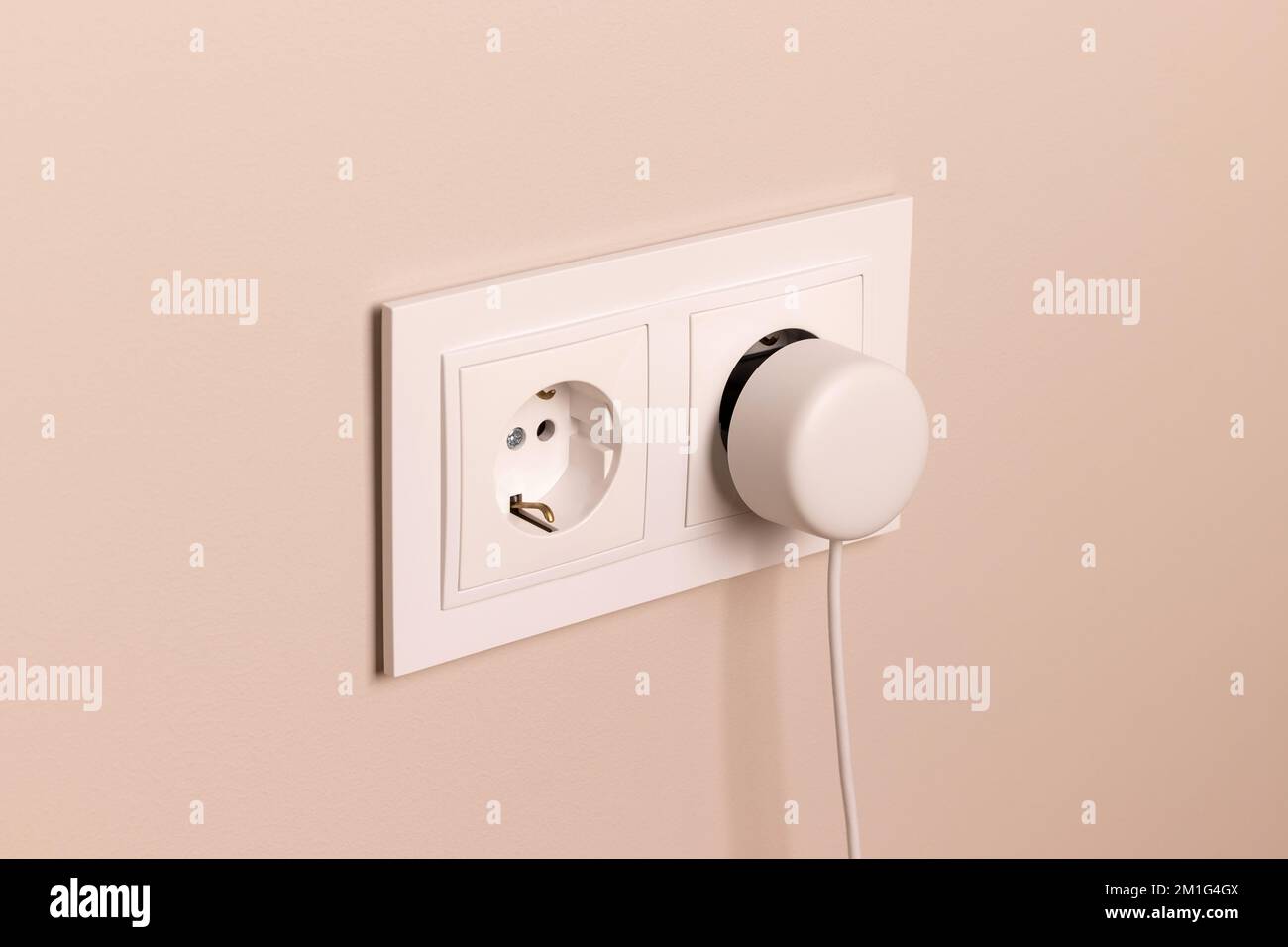Group of white european electrical outlets with round plug inserted ...