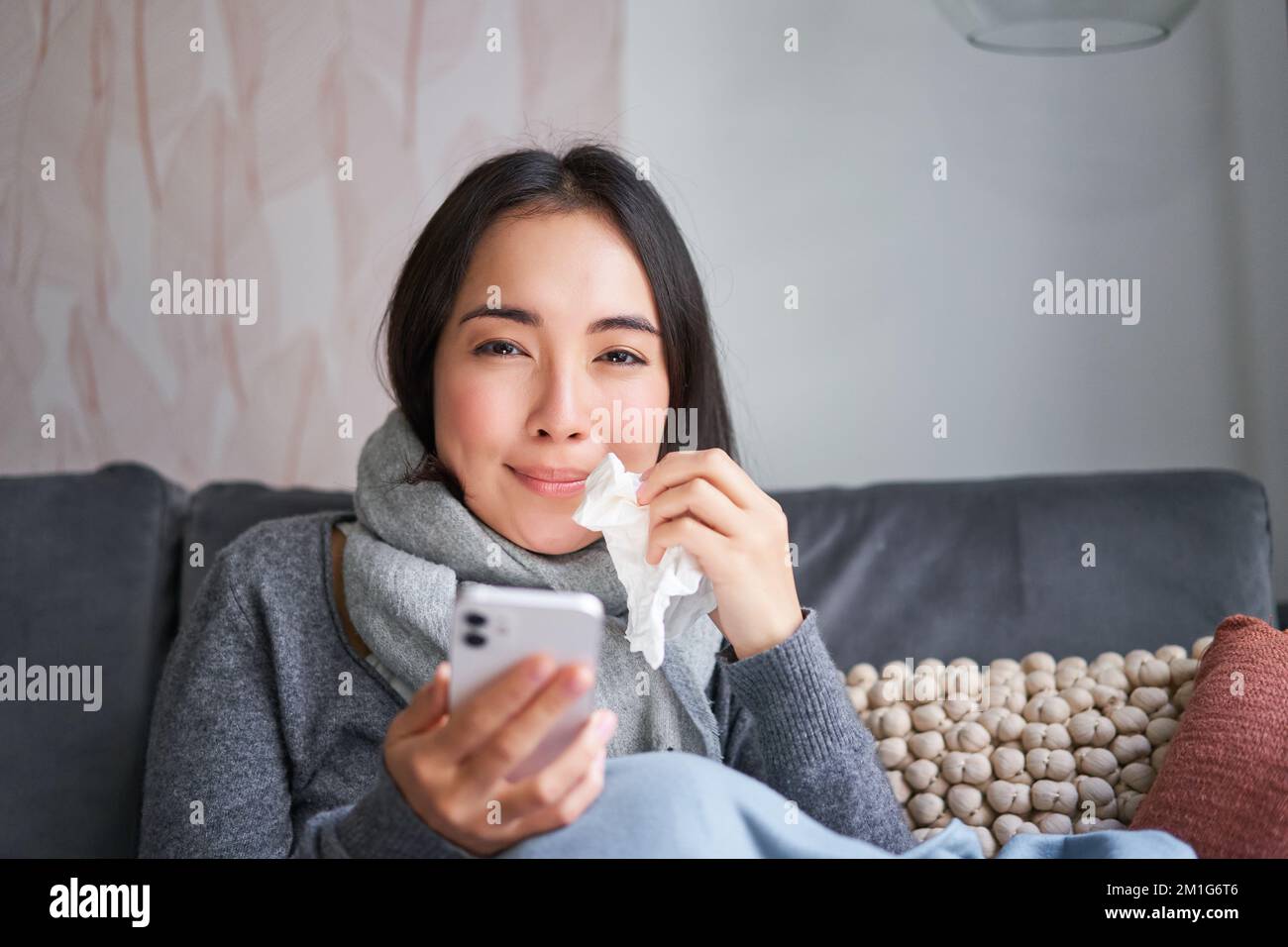 Portrait of sick woman contacting her GP via mobile phone while ...