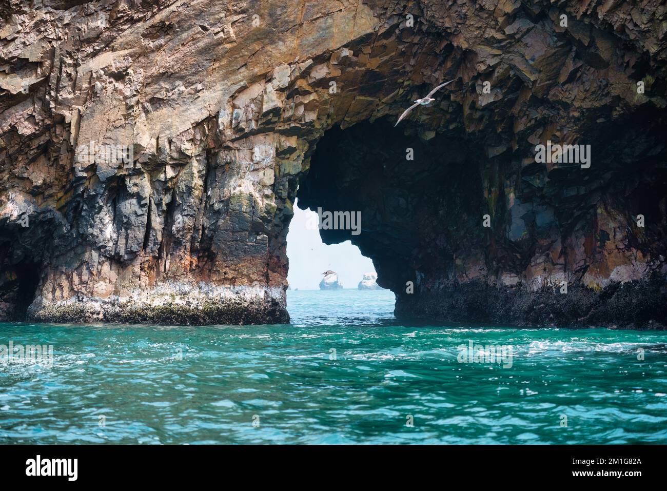 A beautiful shot of a natural cliff arch at the Ballestas Islands, Peru ...