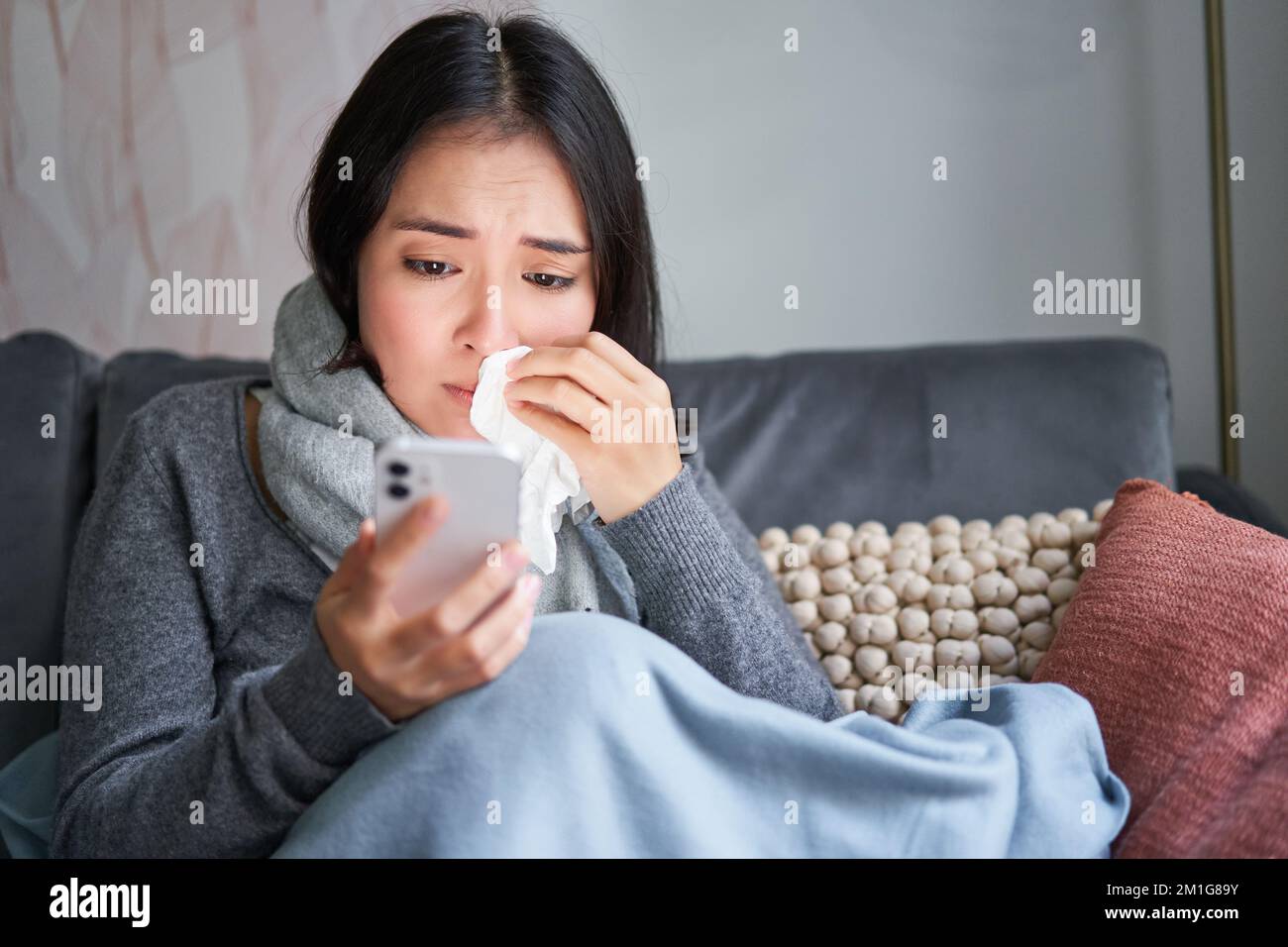Portrait of sick woman contacting her GP via mobile phone while ...