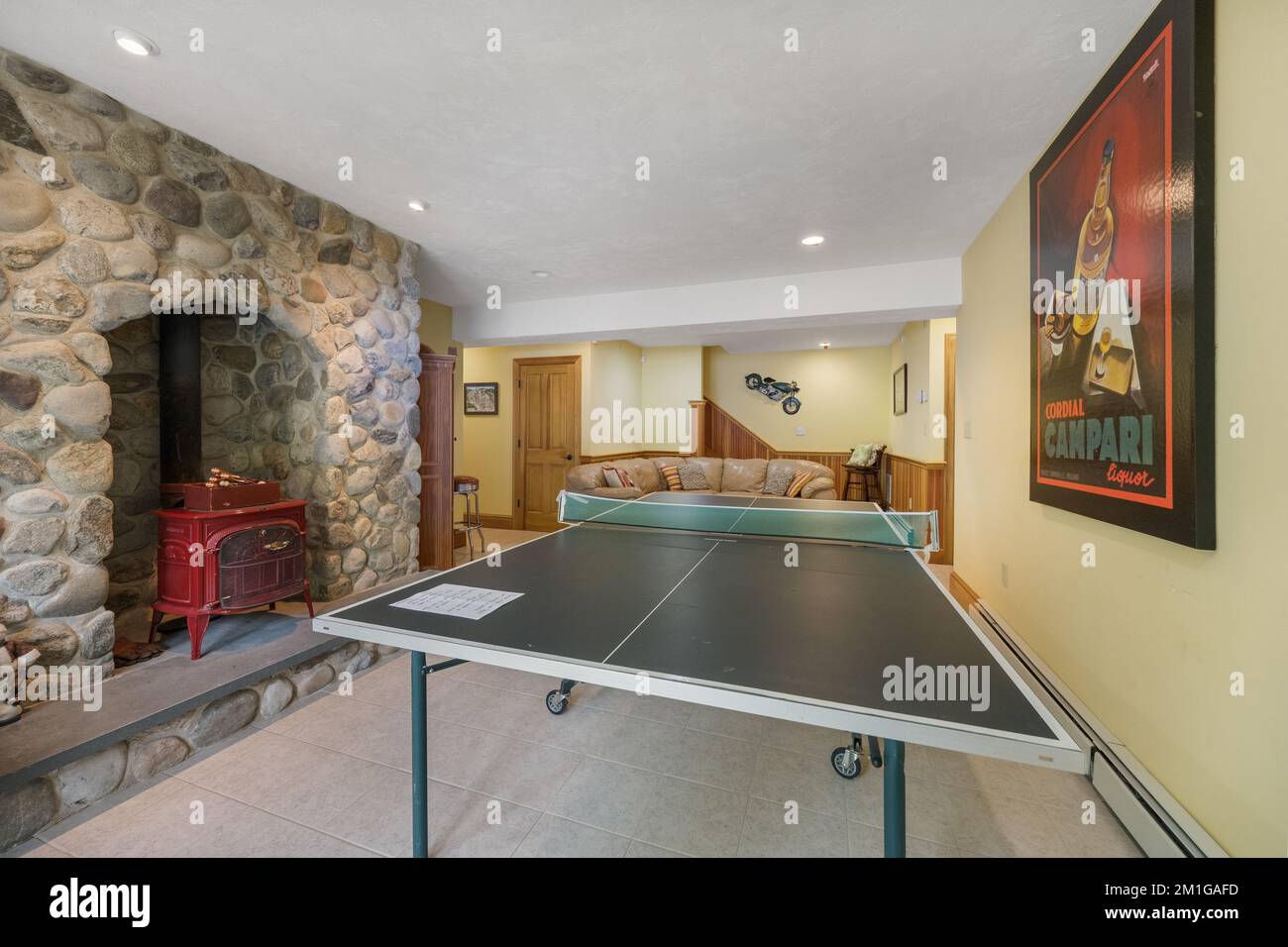 An interior shot of a room with a ping pong table, light yellow walls ...
