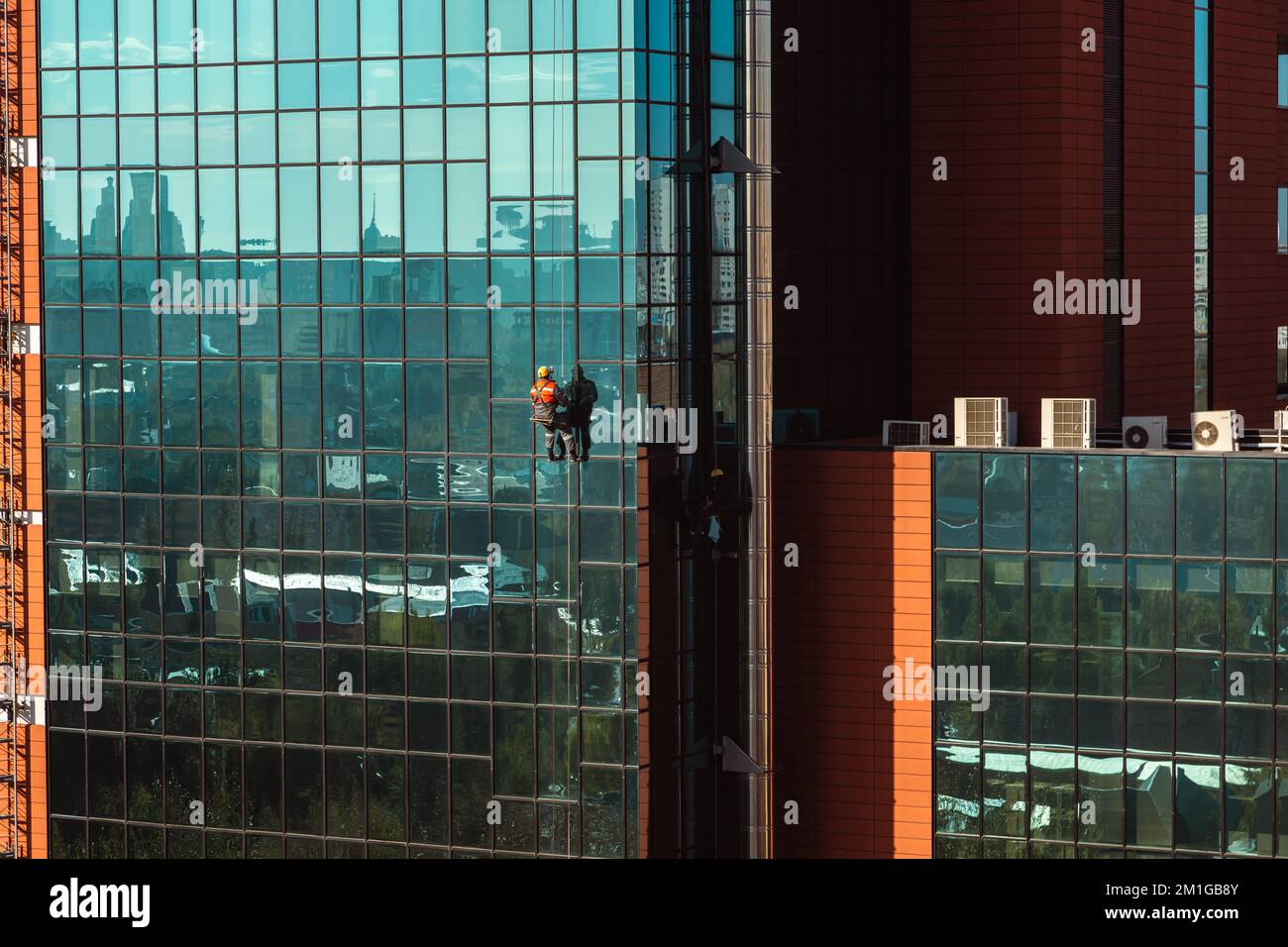 High-rise workers cleaning the windows of a skyscraper Stock Photo - Alamy