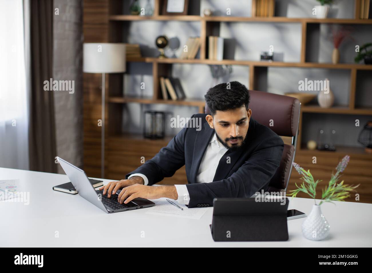 Portrait of a confident bearded man, working at home with laptop on ...
