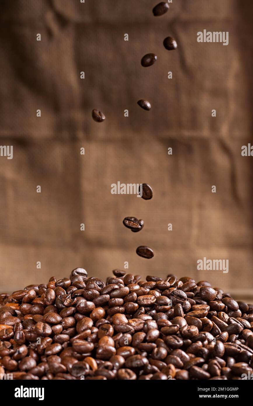 Coffee beans falling on a mountain of roasted coffee beans Stock Photo ...