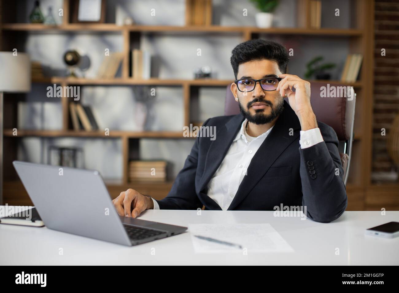 Young bearded businessman using laptop computer during video call working in office ...