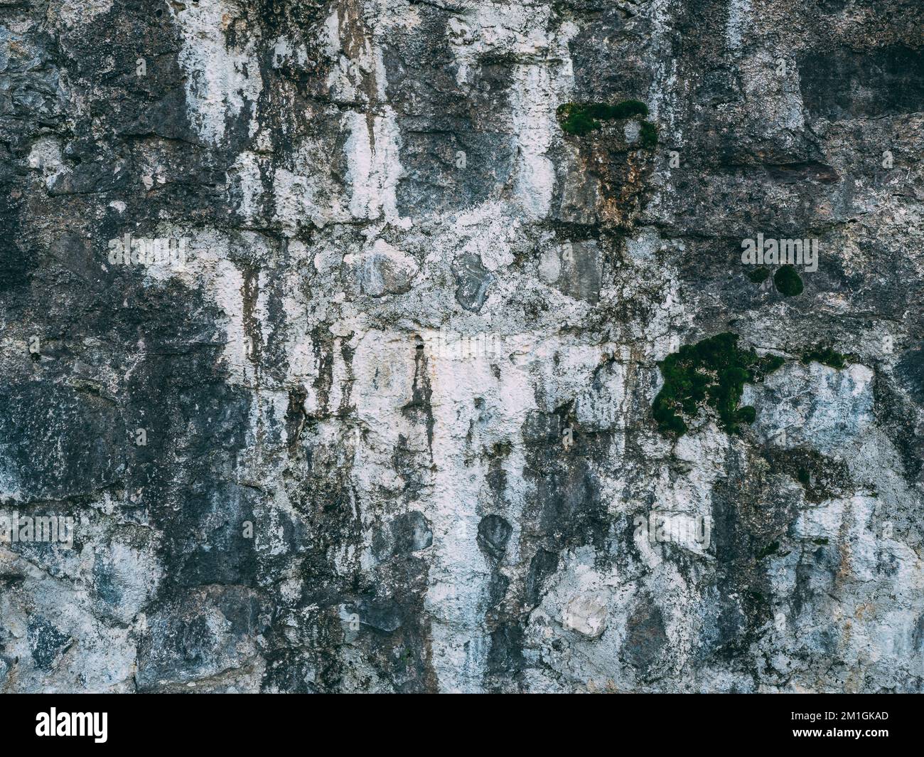 Surface of weathered old stone ancient building wall covered with mold ...