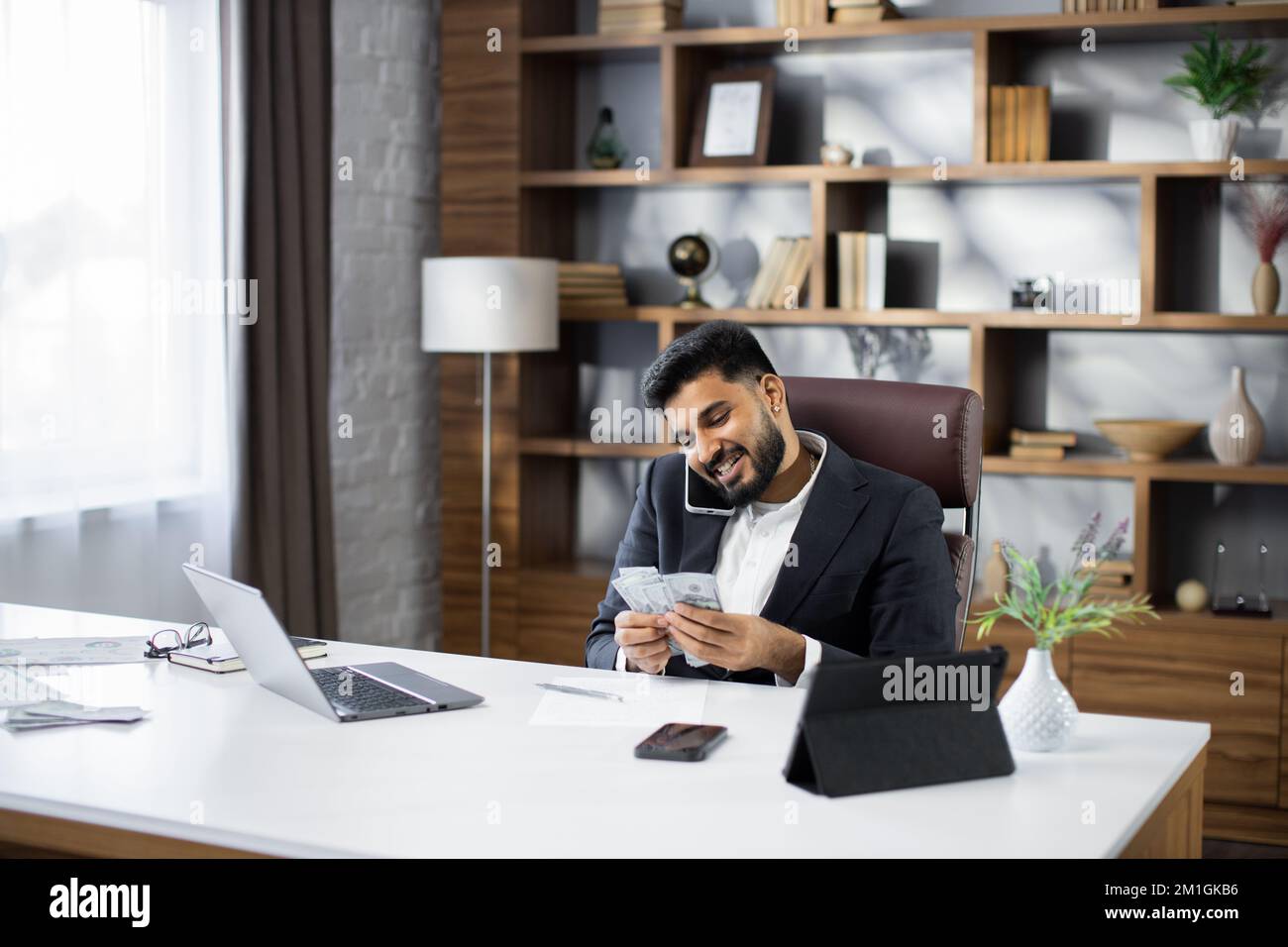 Rich business man working on smartphone counting money cash, calculate ...