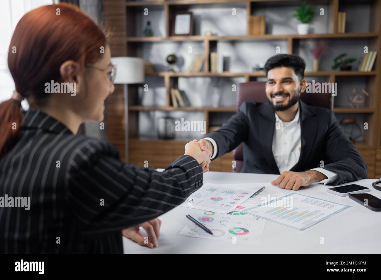 Greetings, you are hired. Happy caucasian female job seeker shake hand ...