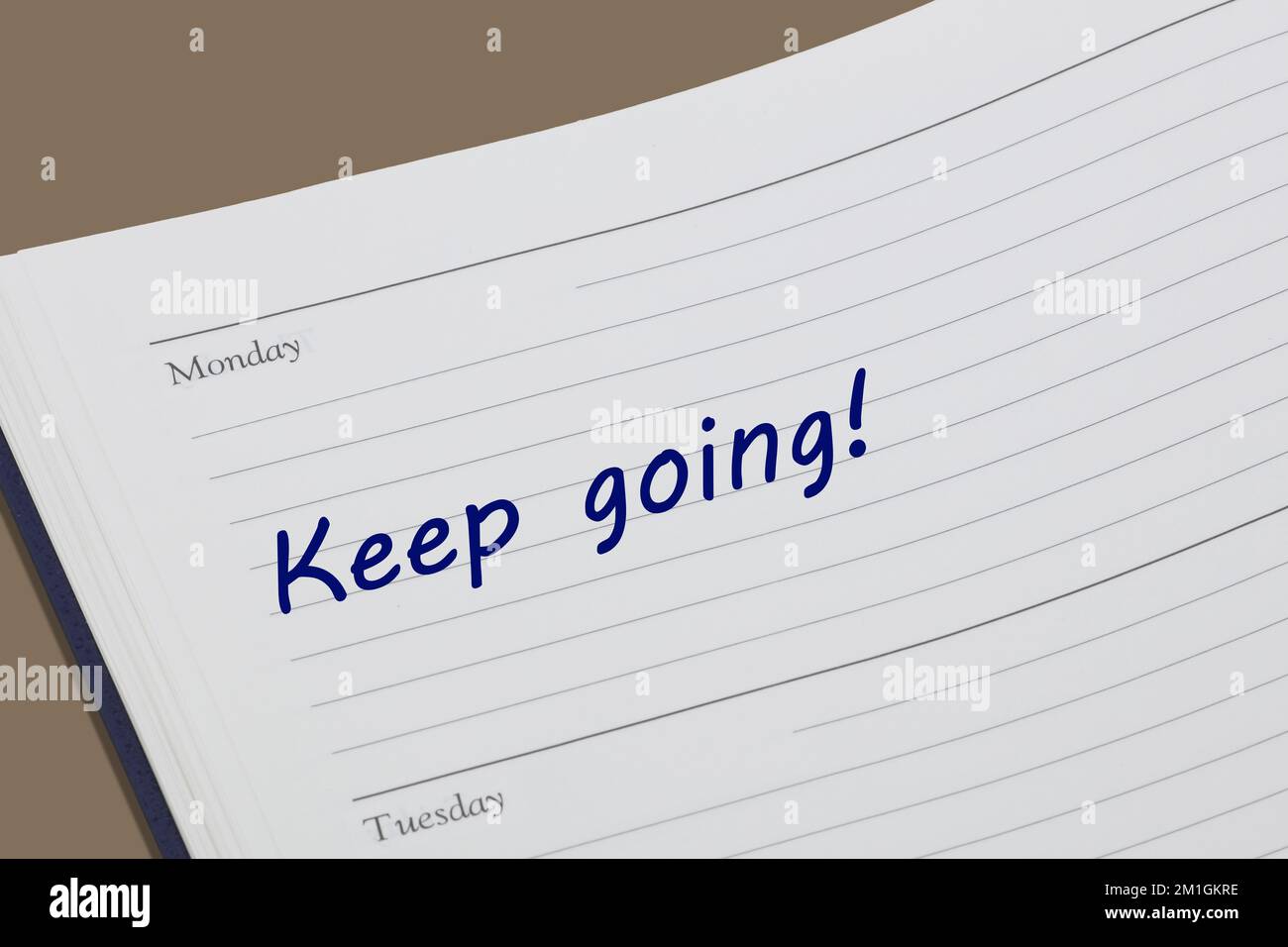 Keep going diary reminder message open on desk Stock Photo - Alamy