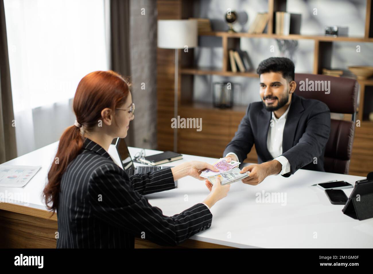 Attractive young businessman and businesswoman are holding large ...