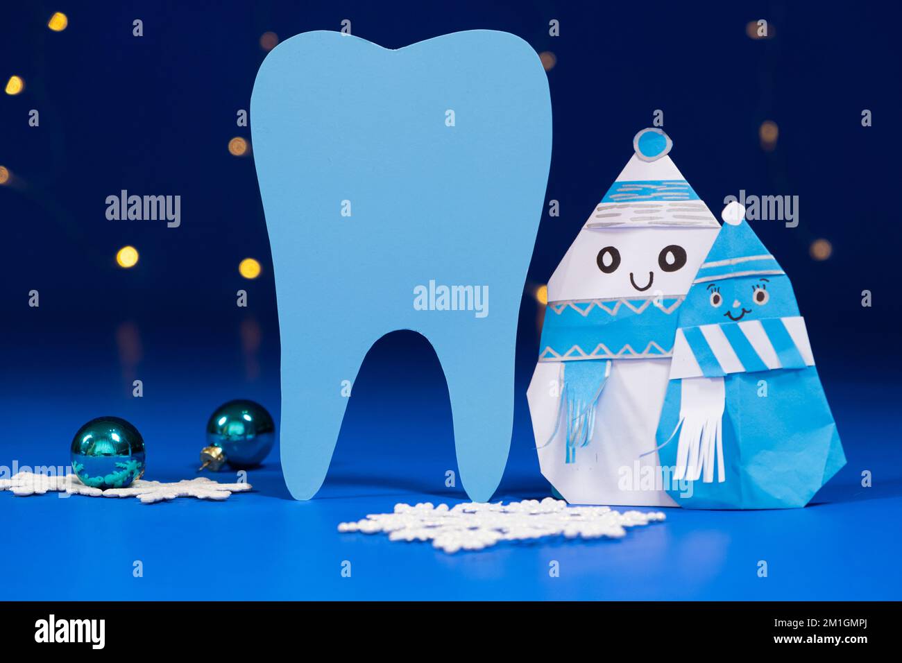 Christmas dentistry - big tooth, snowmen and balls on a blue background ...