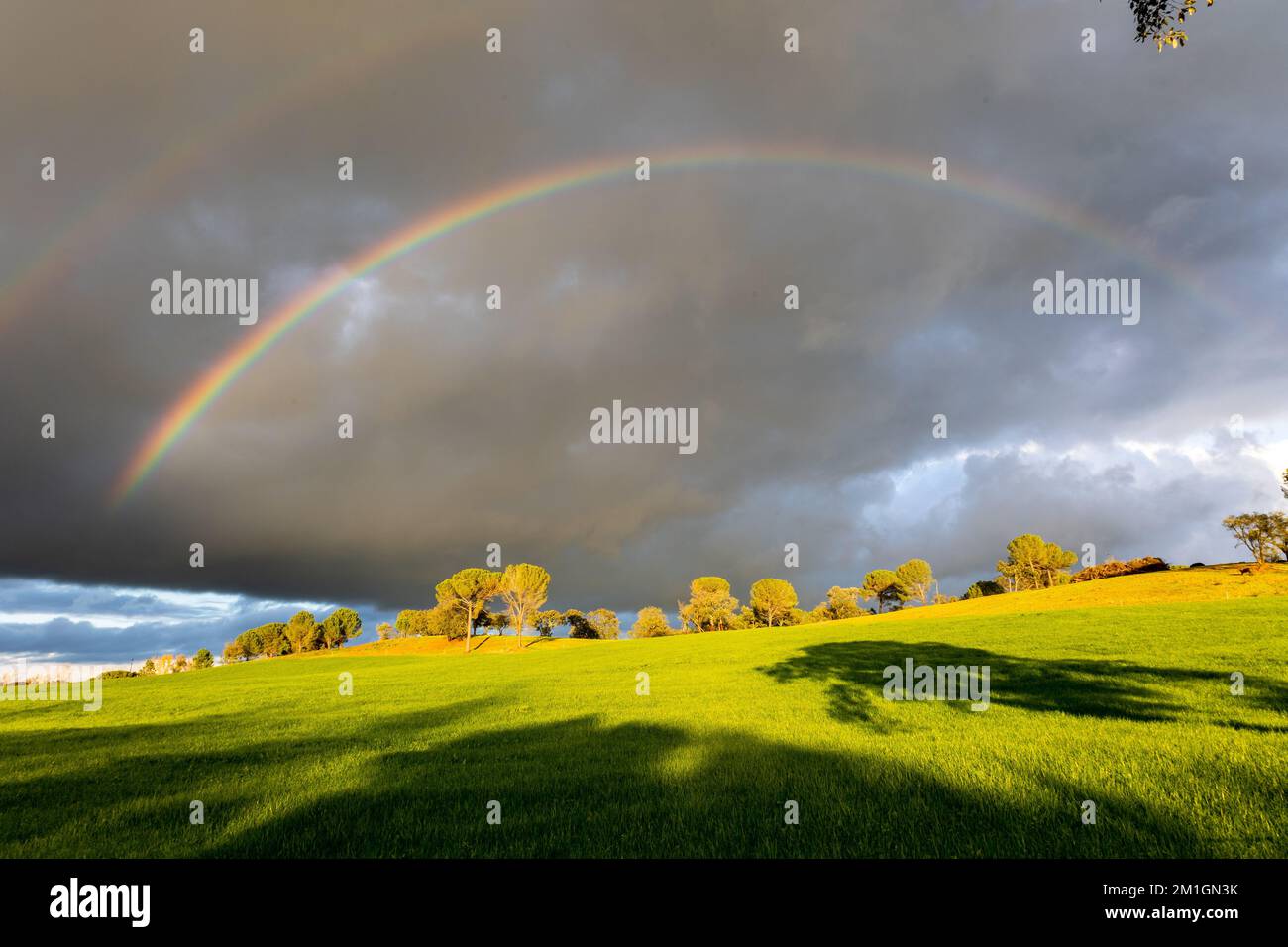 Double rainbow with dark rain clouds just before storm Stock Photo - Alamy