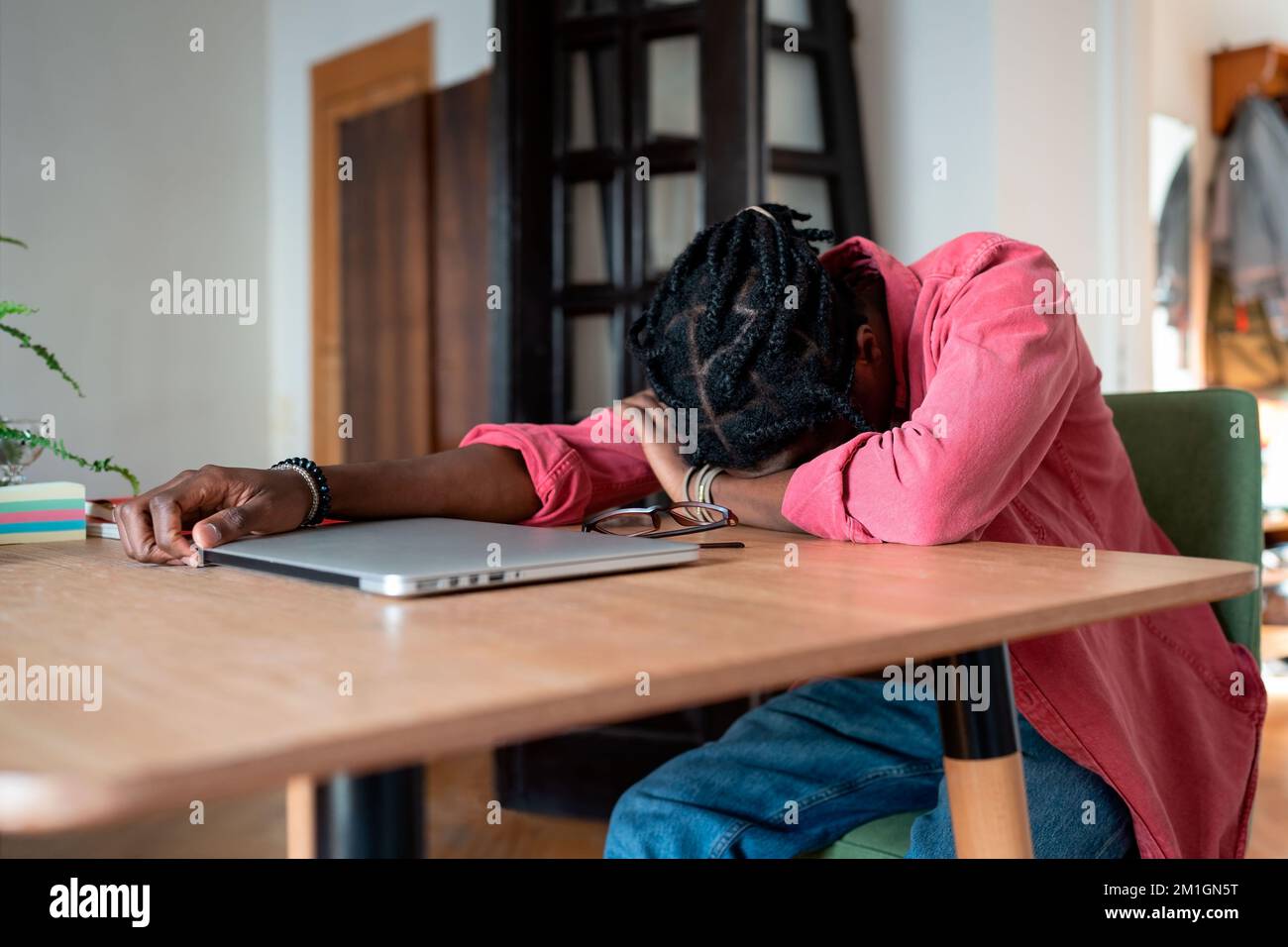 Exhausted overloaded African guy remote worker sleeping on desk ...