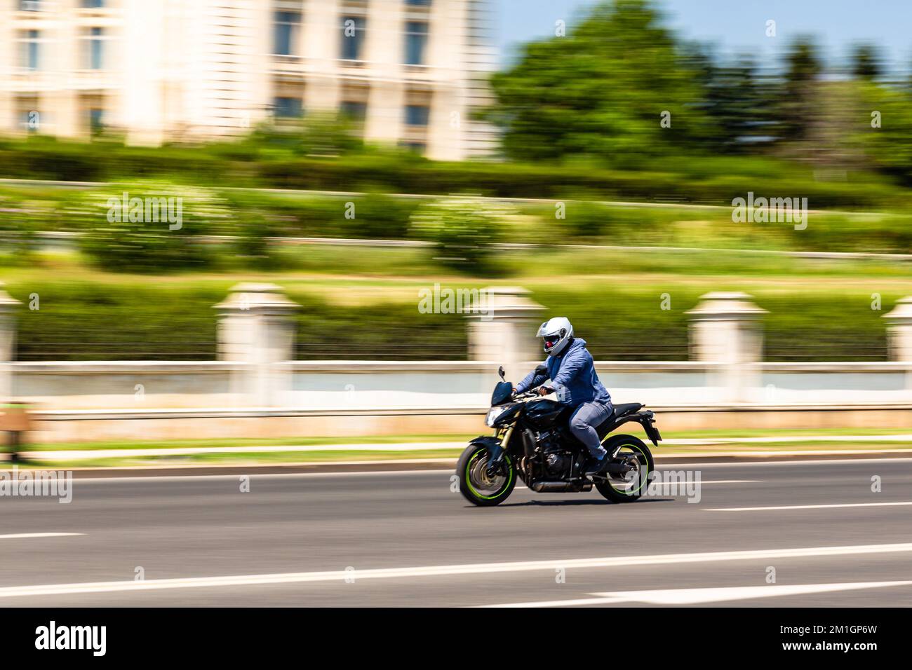 Biker on a motorcycle in traffic at rush hour in downtown area of the ...