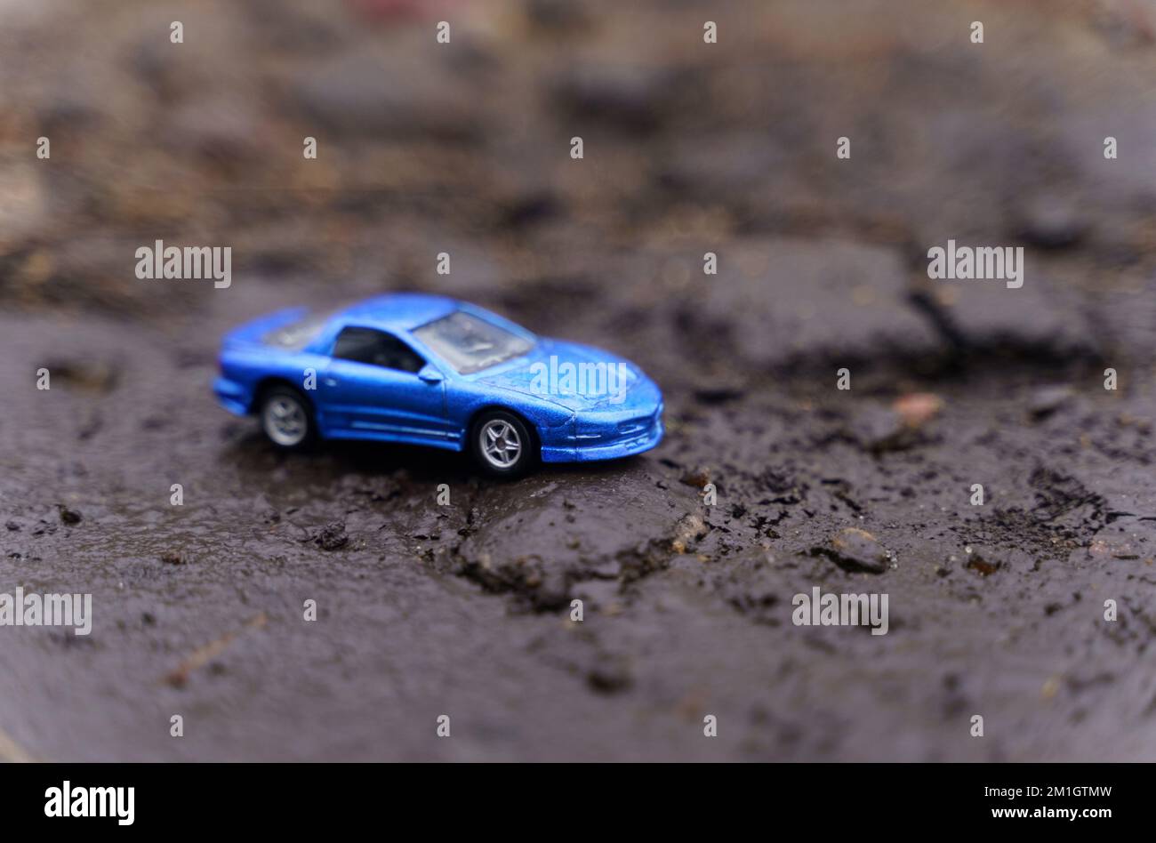 Natural disasters. A blue car drives along a road destroyed by a ...