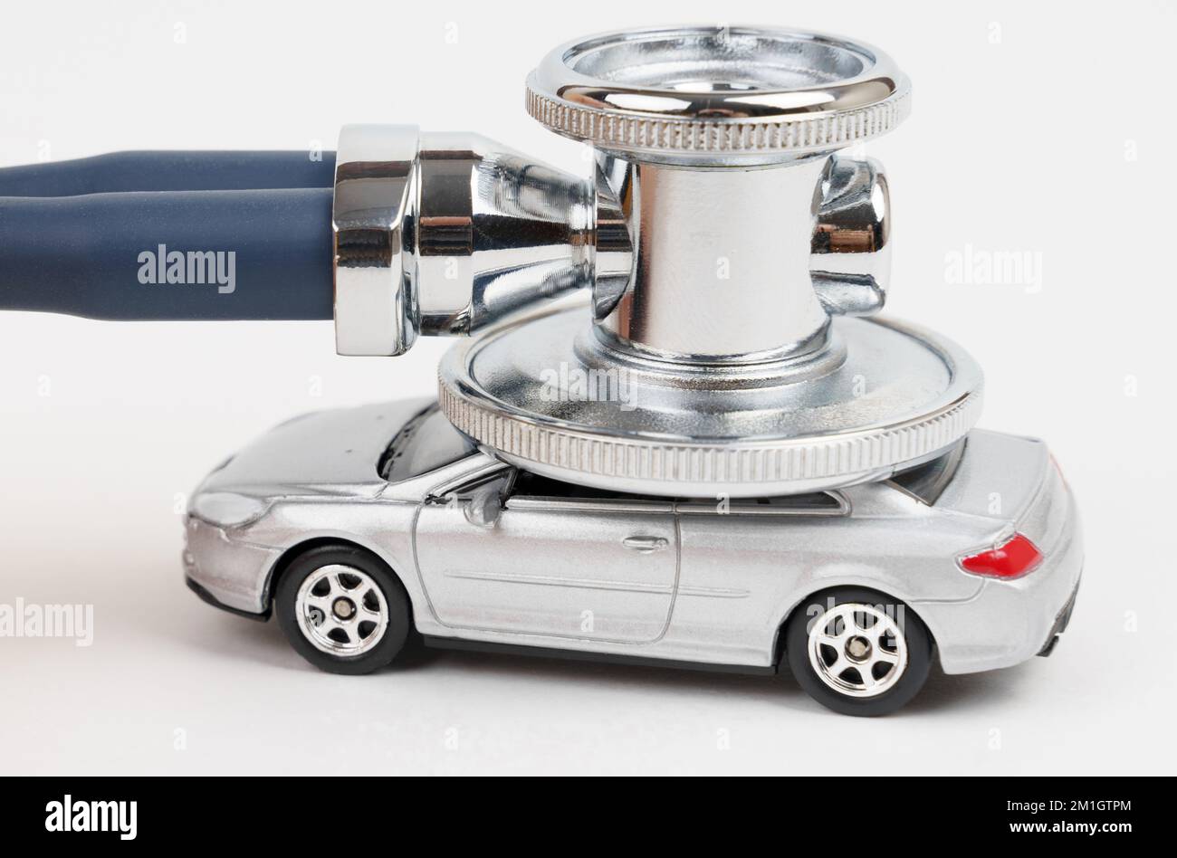 Automotive diagnostics. A stethoscope lies on the roof of a toy car ...
