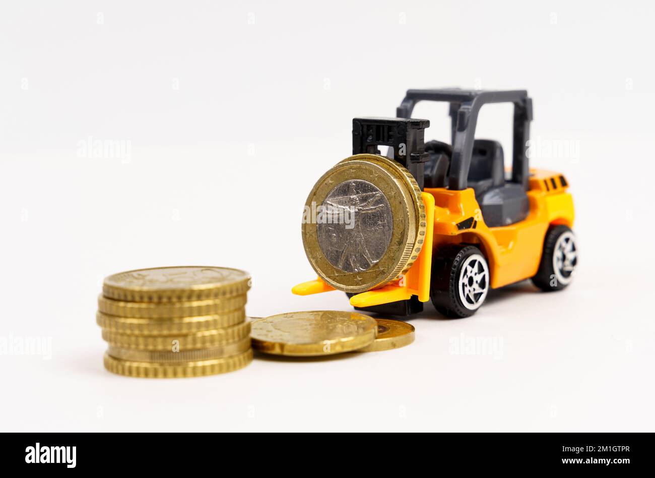 Business and economy concept. A toy loader transports coins. Isolated ...