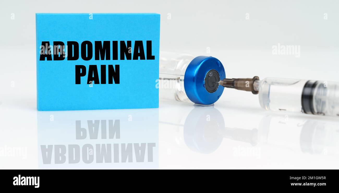 Medicine concept. On a white reflective surface are a syringe, an ...