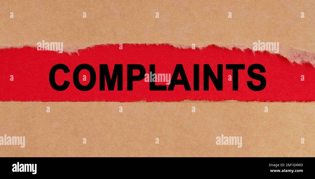 Law concept. Among the torn sheets of paper on a red background, the inscription - COMPLAINTS ...