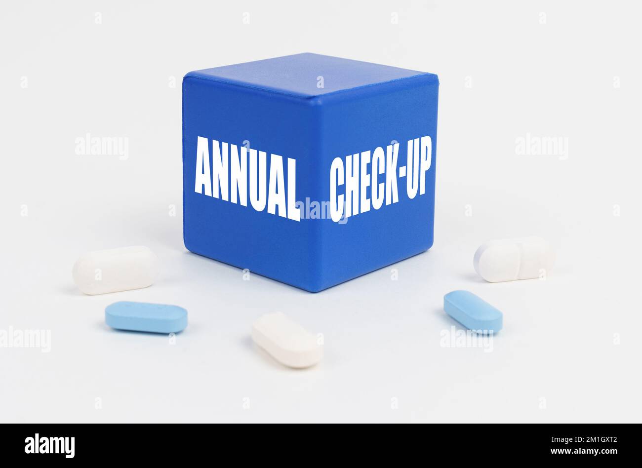 Medicine and health concept. On a white surface are pills and a blue ...