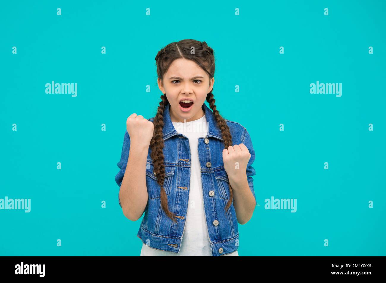 Lost her temper. Bad girl. Angry kid shake fists blue background. Bad ...