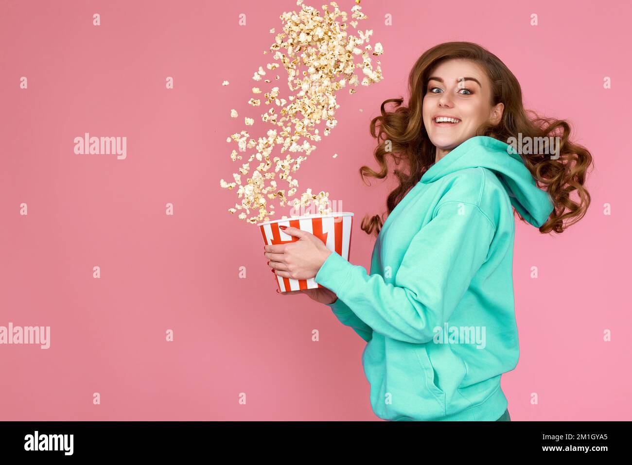 woman holding bucket of popcorn and jumping Stock Photo - Alamy