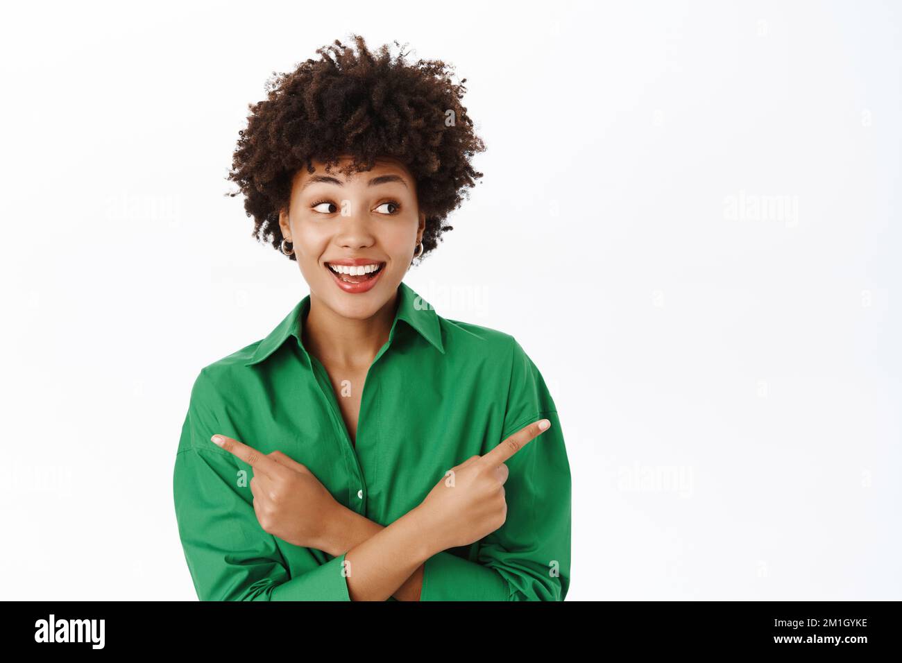 Portrait of beautiful african american woman pointing fingers sideways ...