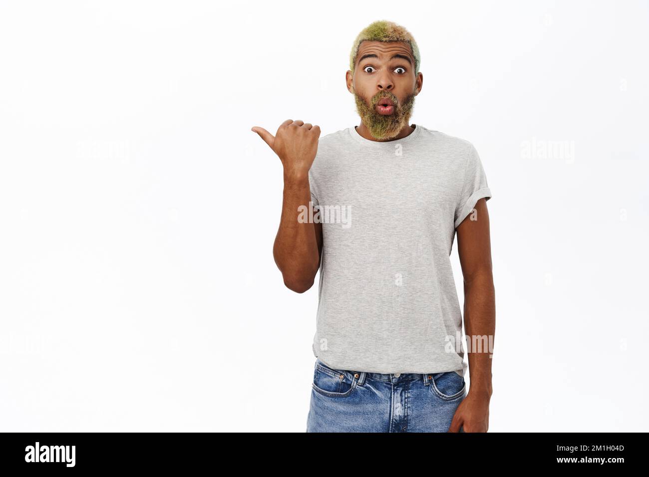 Impressed guy with yellow beard, african american man pointing left ...