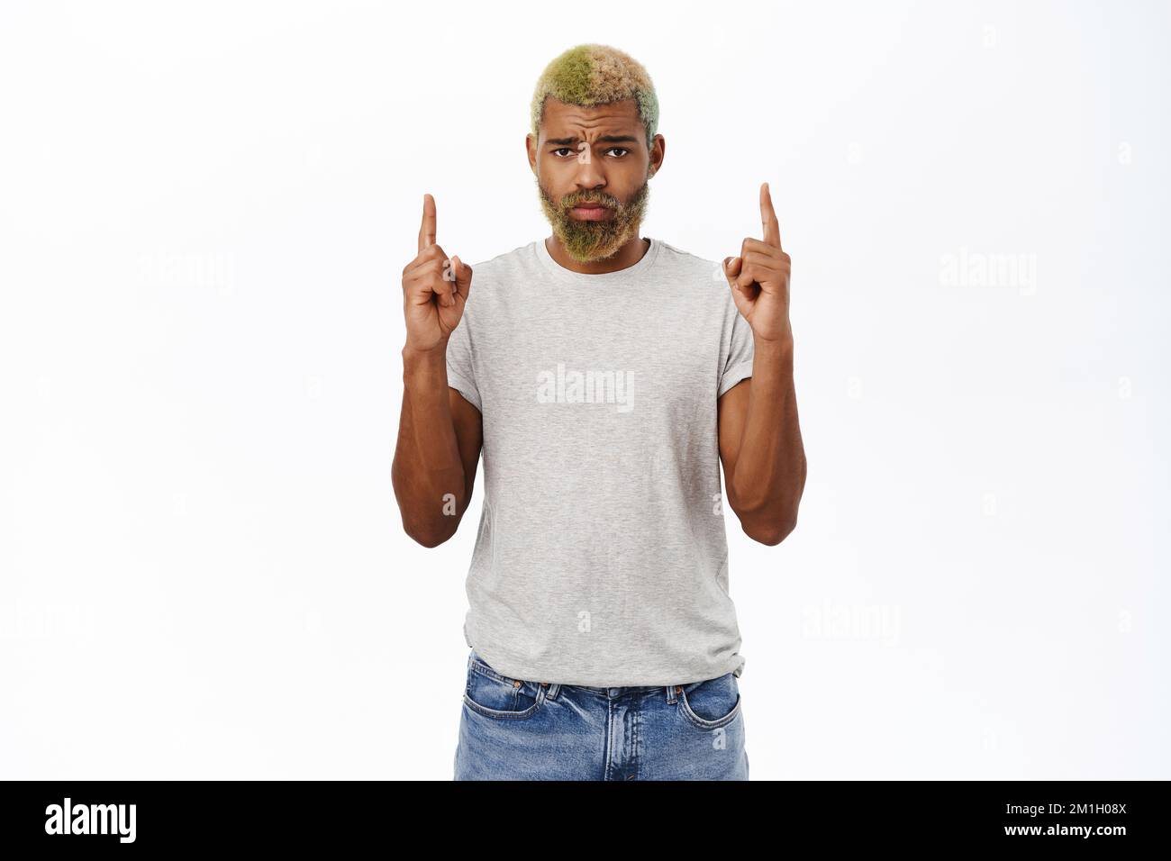 Sad african american hipster guy pointing fingers up, sulking and ...