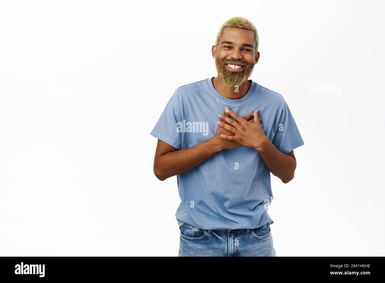 Thank you. Happy smiling man holds hands on heart and looks with ...