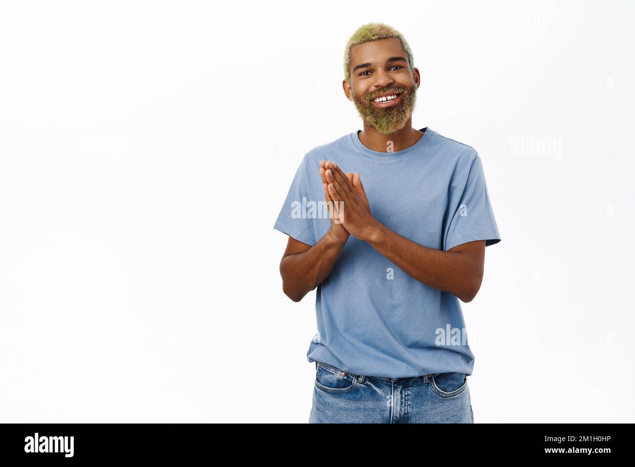 Image of young hopeful guy looking with happy smile, hold hands in pray ...