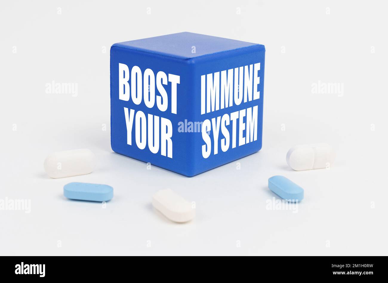 Medicine and health concept. On a white surface are pills and a blue ...