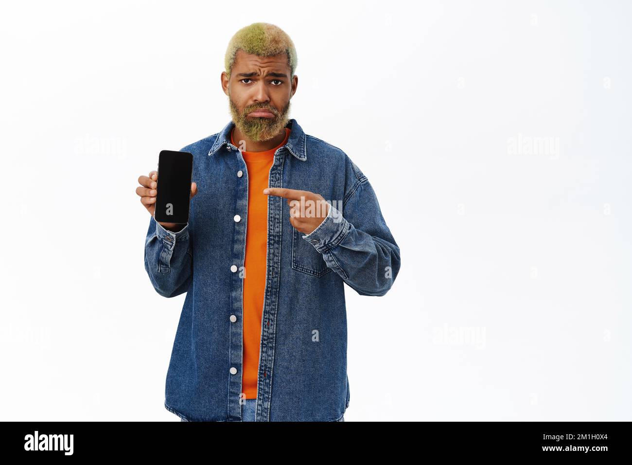 Man with sad face pointing at his mobile phone screen, complains at ...