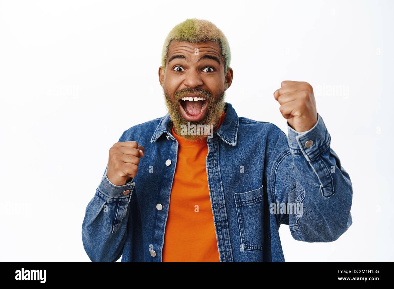 Portrait of enthusiastic man raising fists up, chanting, cheering and ...