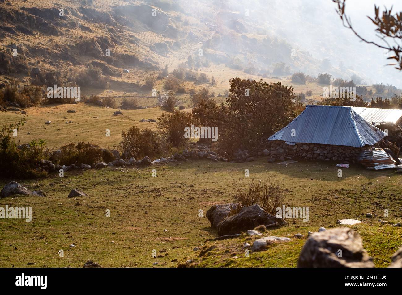 A small stone hut in the Peruvian Andes with foggy rocks in the ...
