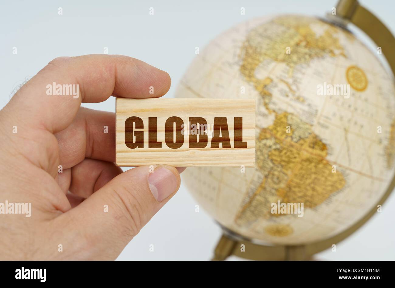 Globalization concept. A man holds in his hand a wooden plate on which ...