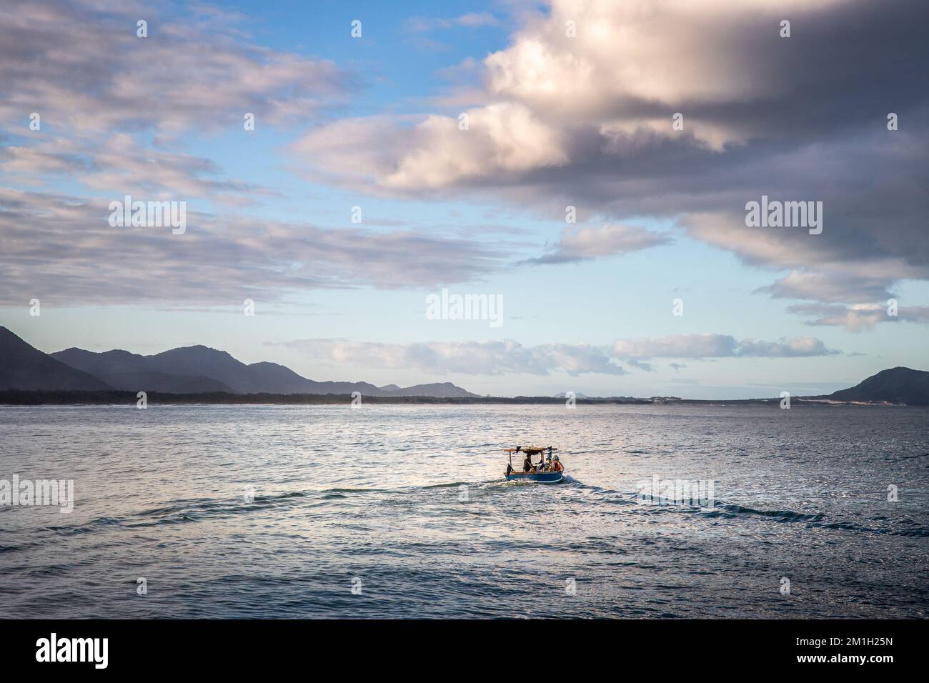 A landscape view of a boat sailing on the beach Stock Photo - Alamy