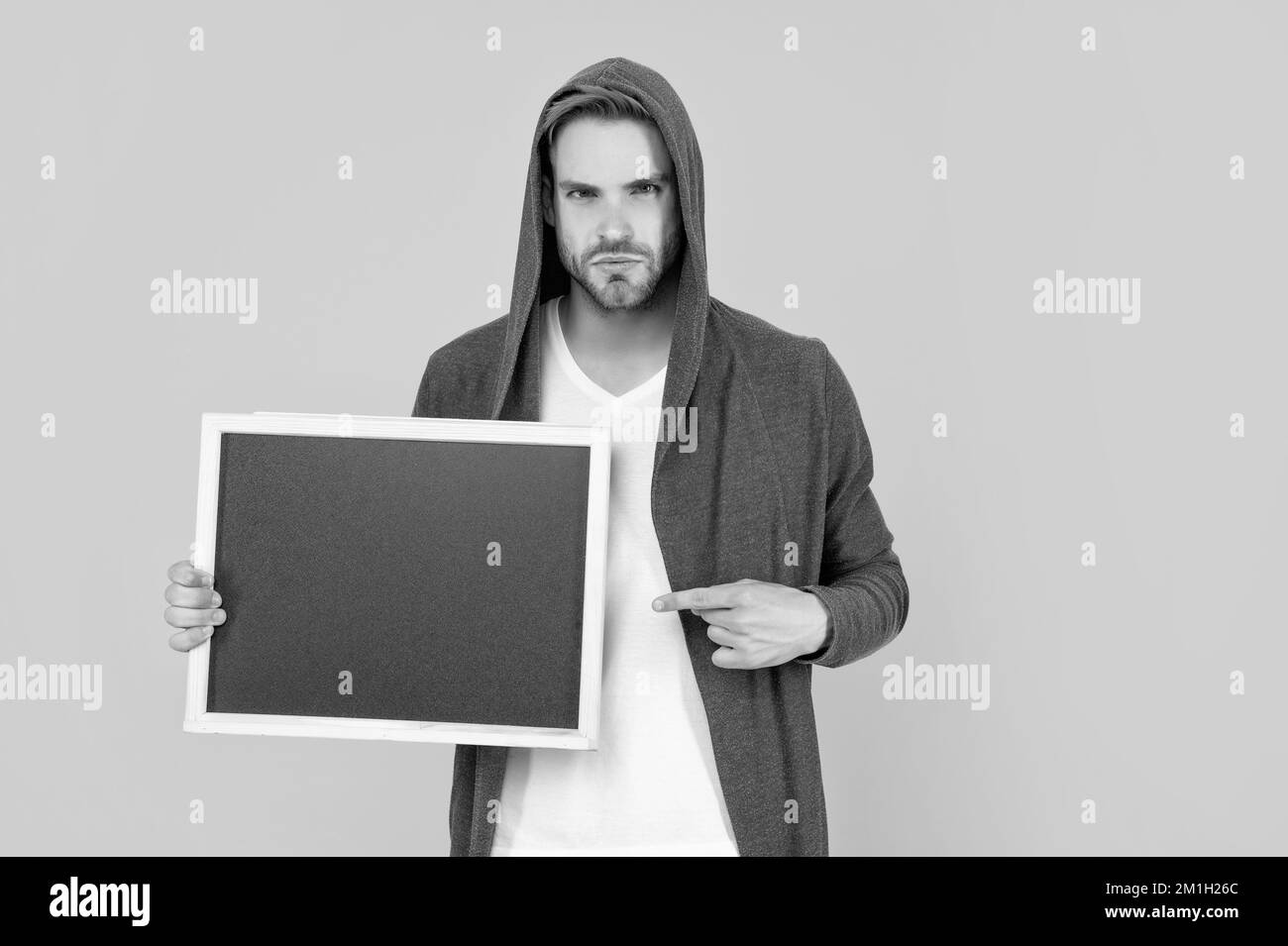 man presenting advertisement with copy space on yellow background ...