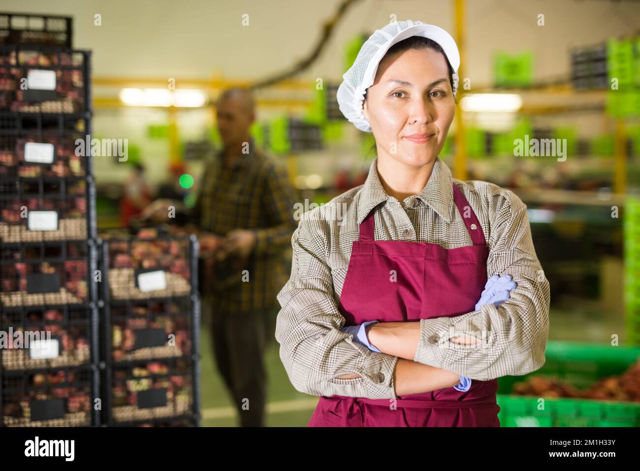 Female worker with arms crossed standing in warehouse Stock Photo - Alamy