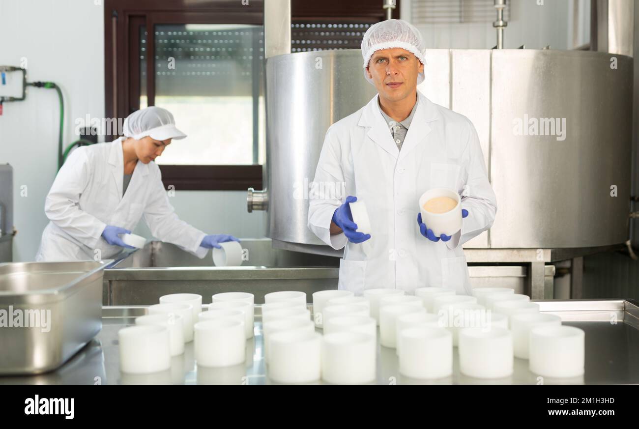 Handsome cheesemaker is making curd cheese in workshop Stock Photo - Alamy