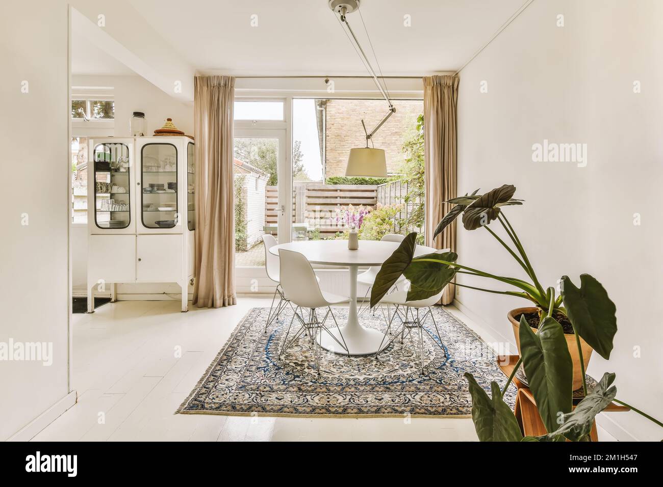 a dining room with a white table and chairs in front of an open door ...
