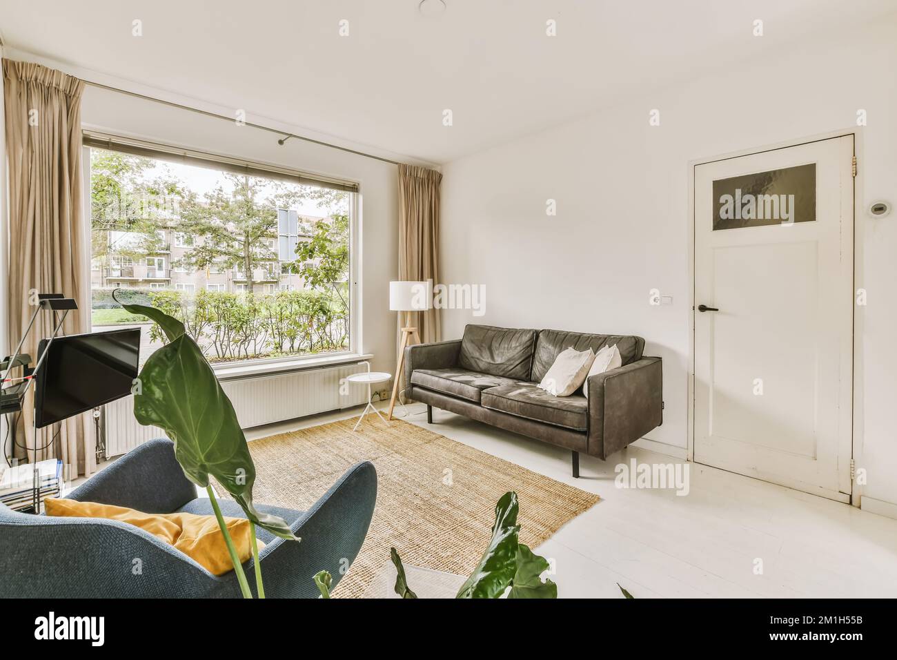 a living room with a couch, chair and television set in front of a ...