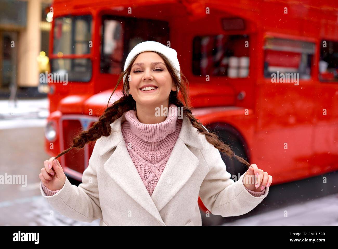 Happy woman near London double decker red old bus in winter, enjoy snow ...
