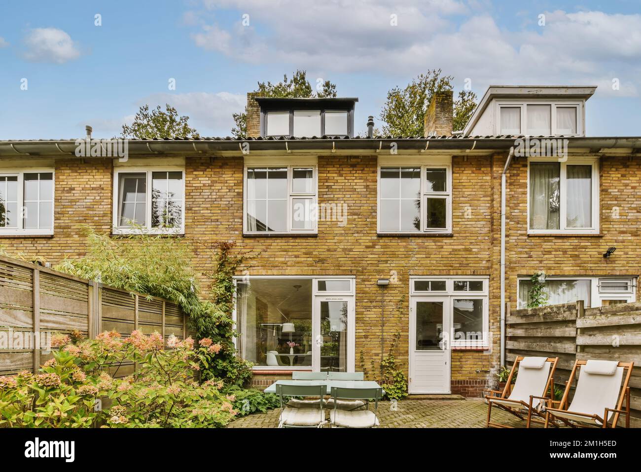 an outside area with furniture and flowers in the fore - image is taken ...