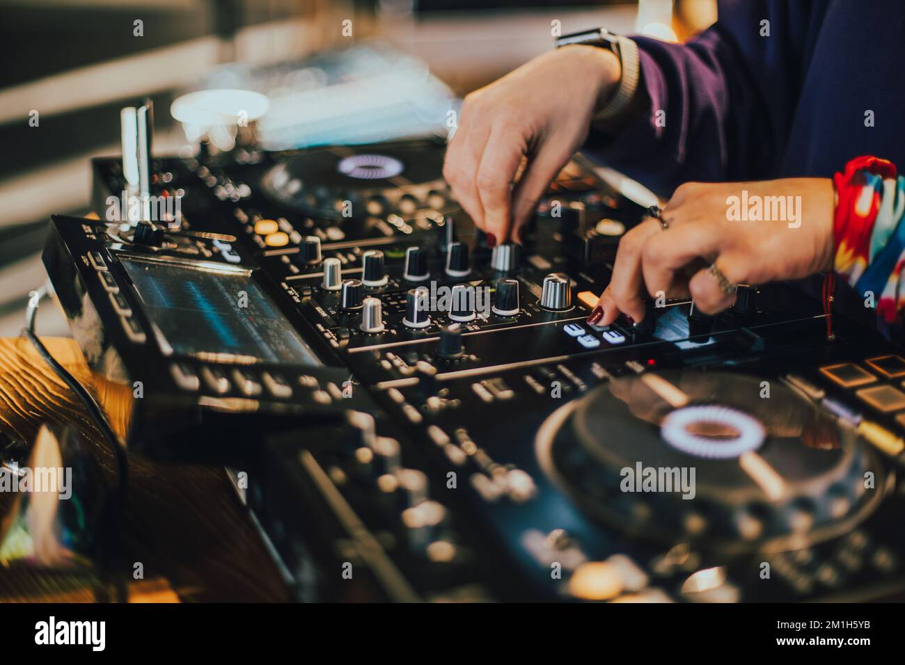 DJ plays live set and mixing music on turntable console on stage at ...