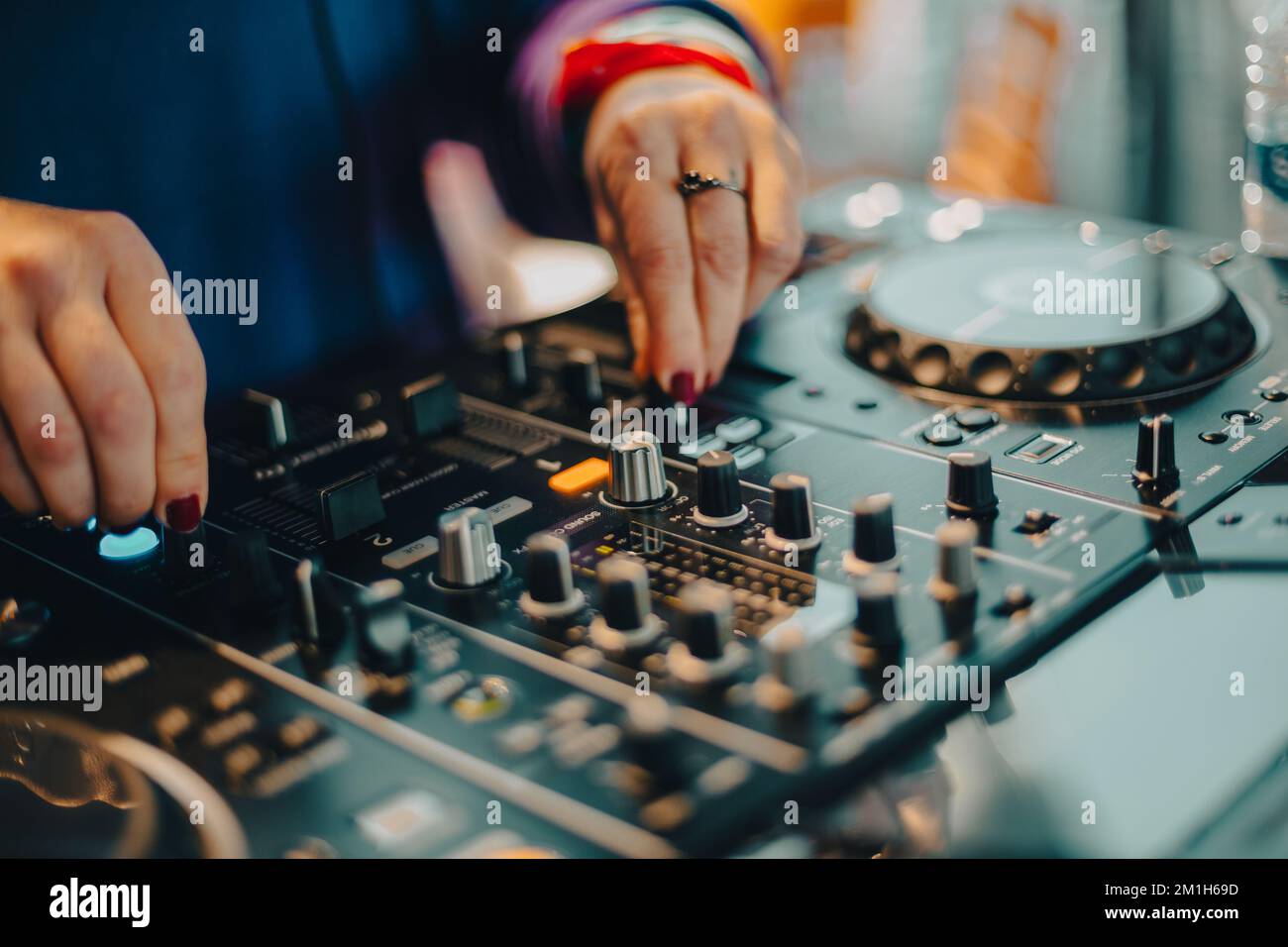 DJ plays live set and mixing music on turntable console on stage at ...