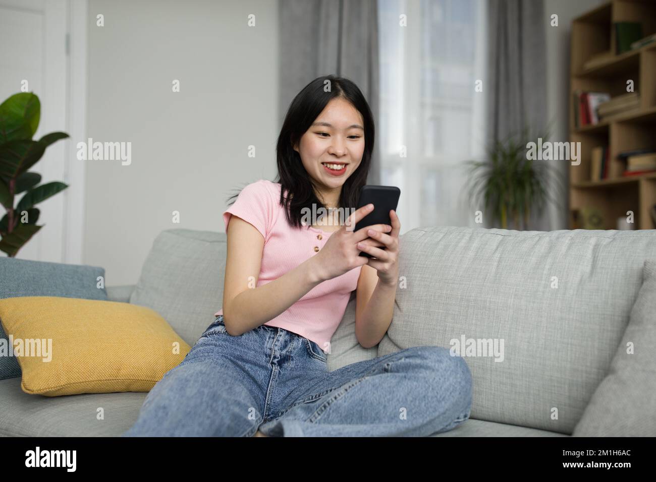 Cool gadget and application. Happy asian lady holding mobile phone ...