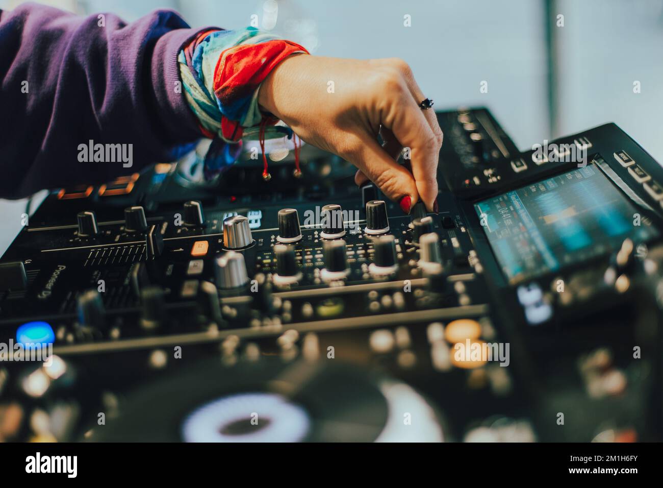 DJ plays live set and mixing music on turntable console on stage at ...